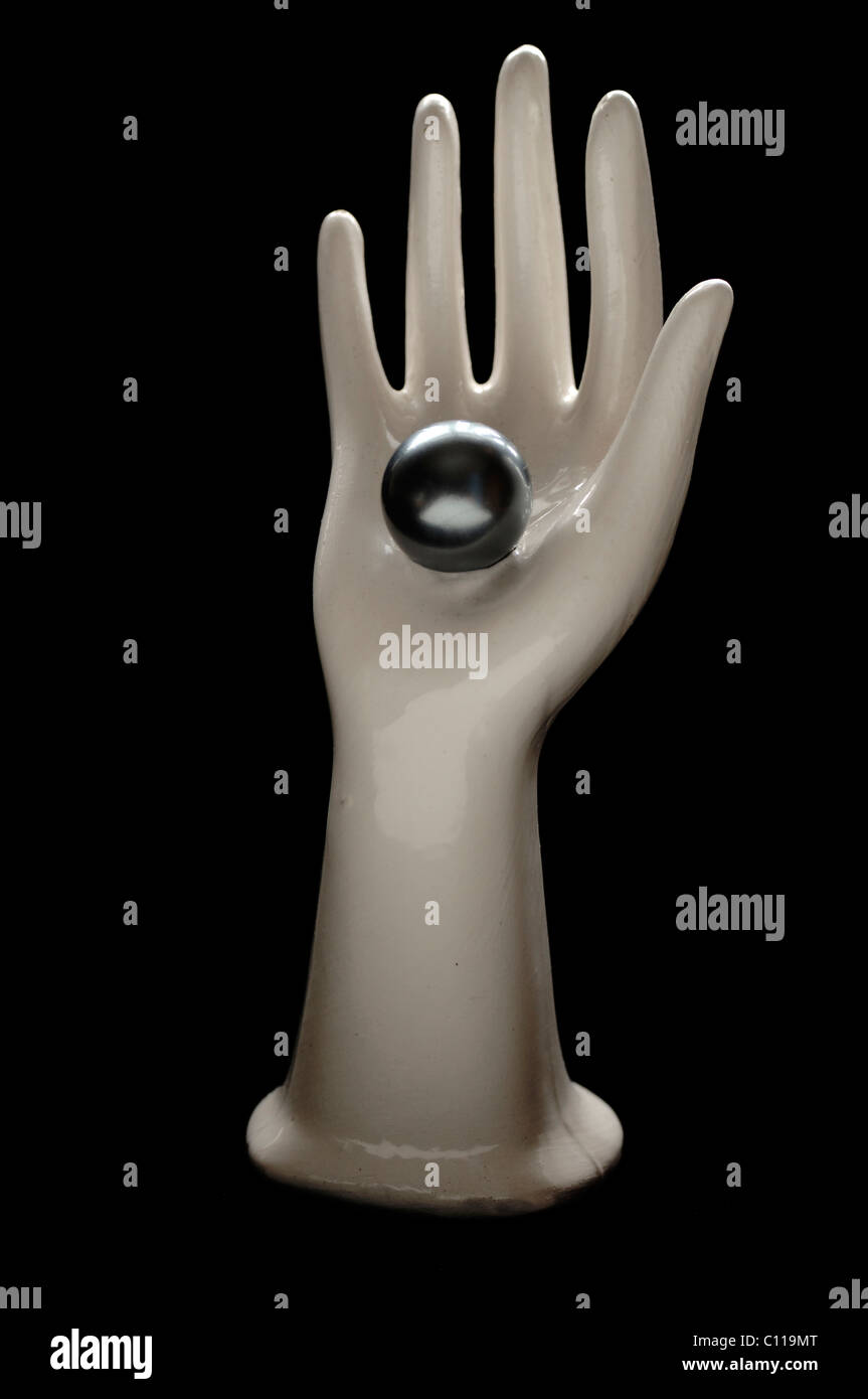 White porcelain hand with large imitation Thahiti pearl, 18mm, on black ...