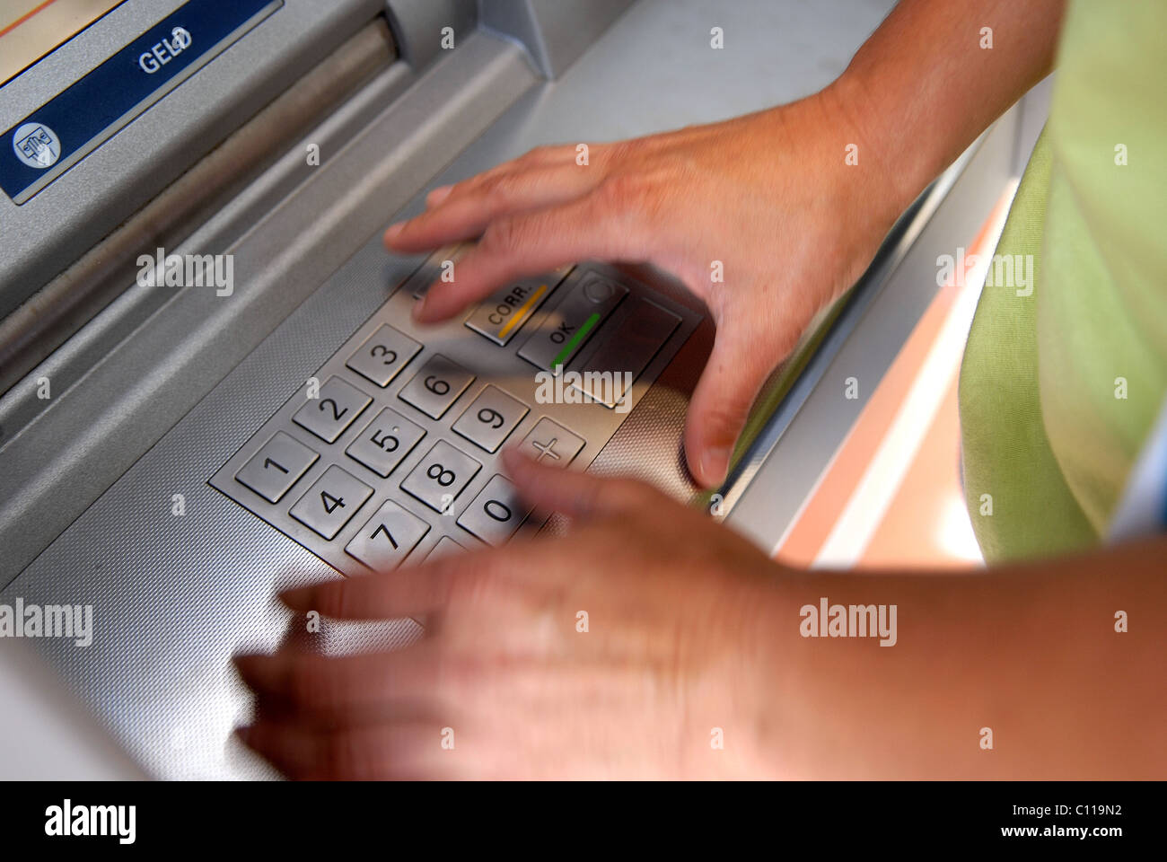 Woman inputting pin into atm machine Stock Photo - Alamy
