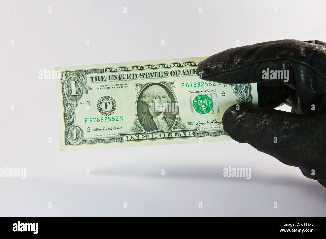 Thief with gloved hand stealing a dollar bill Stock Photo - Alamy