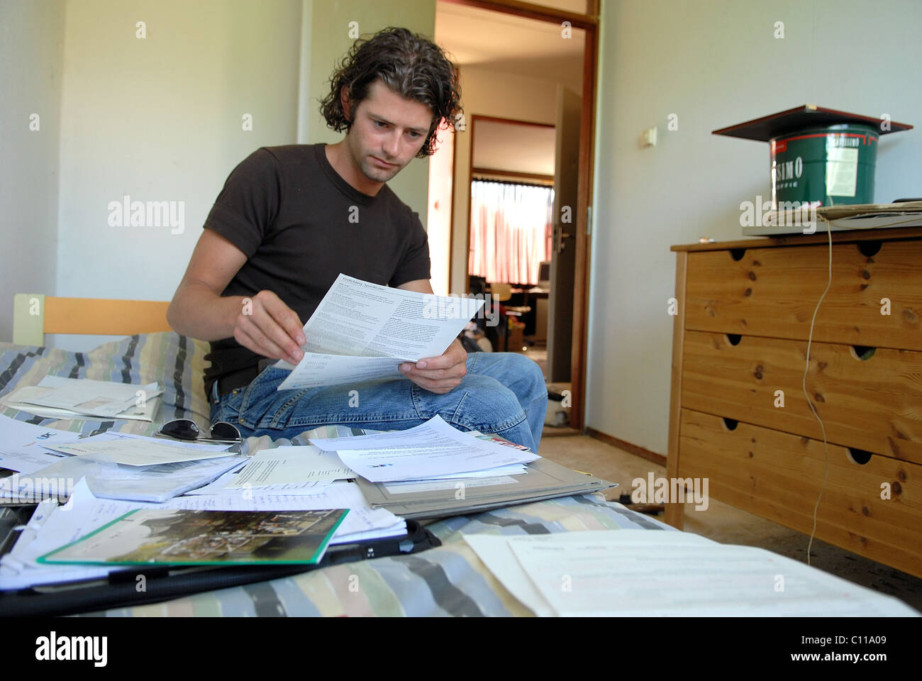 mid adult man going through paperwork on bed Stock Photo - Alamy