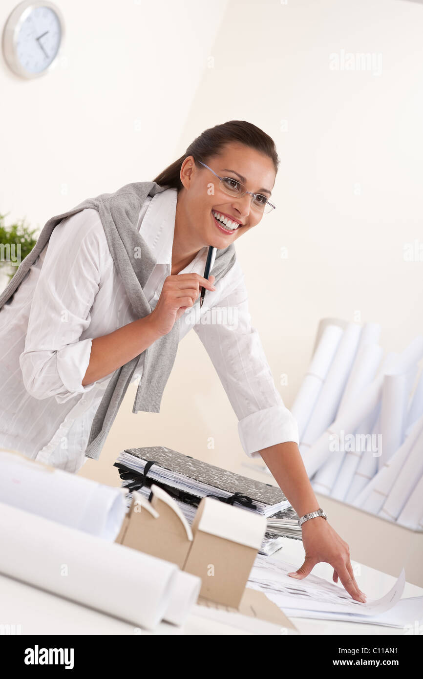 Female architect working with plans at the office holding pen Stock ...