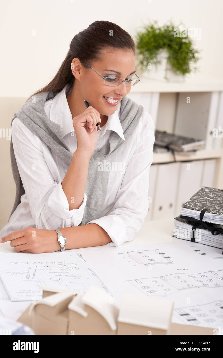 Female architect working with plans at the office holding pen Stock ...