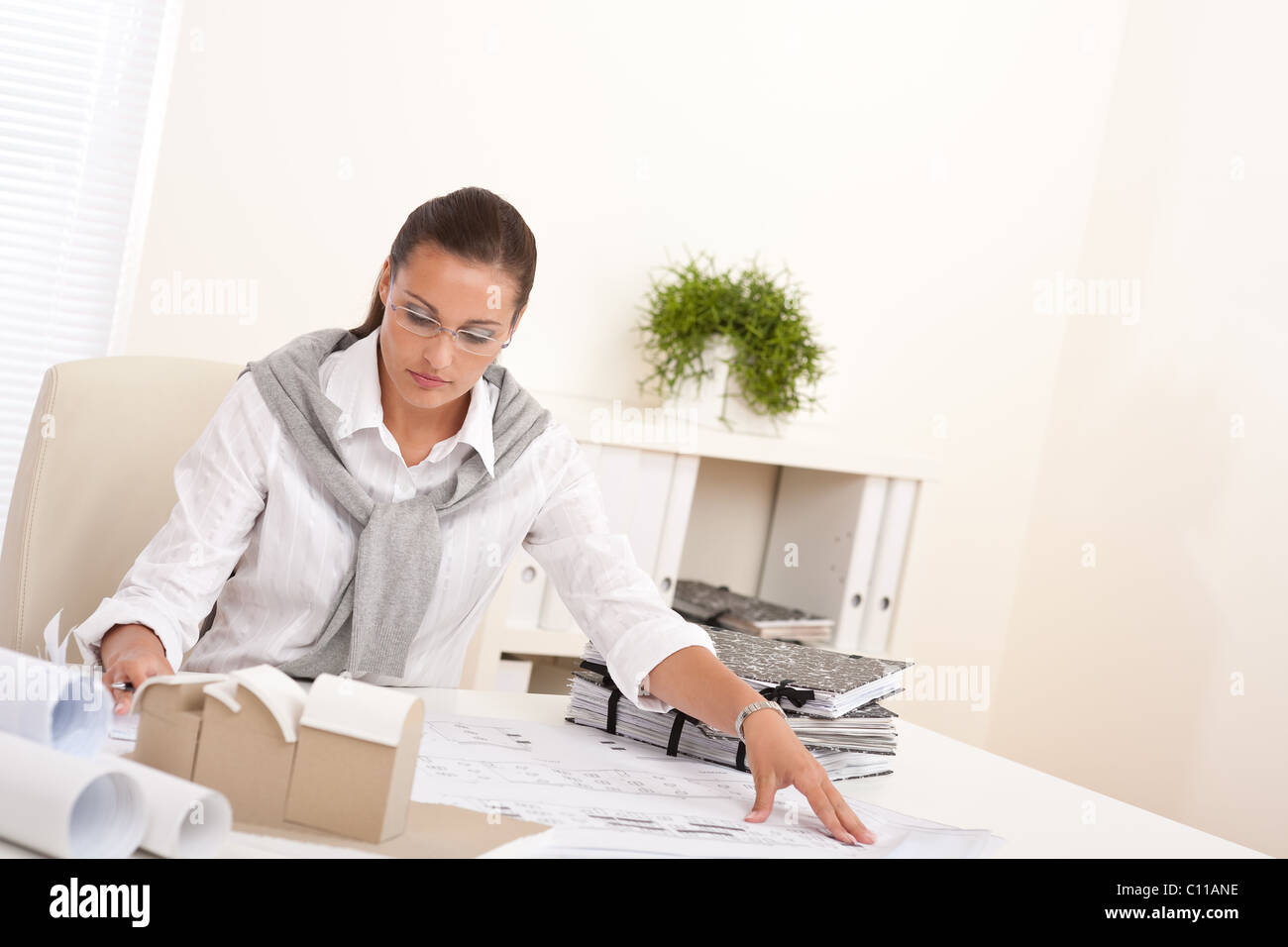 Young female architect working at the office with plans Stock Photo - Alamy