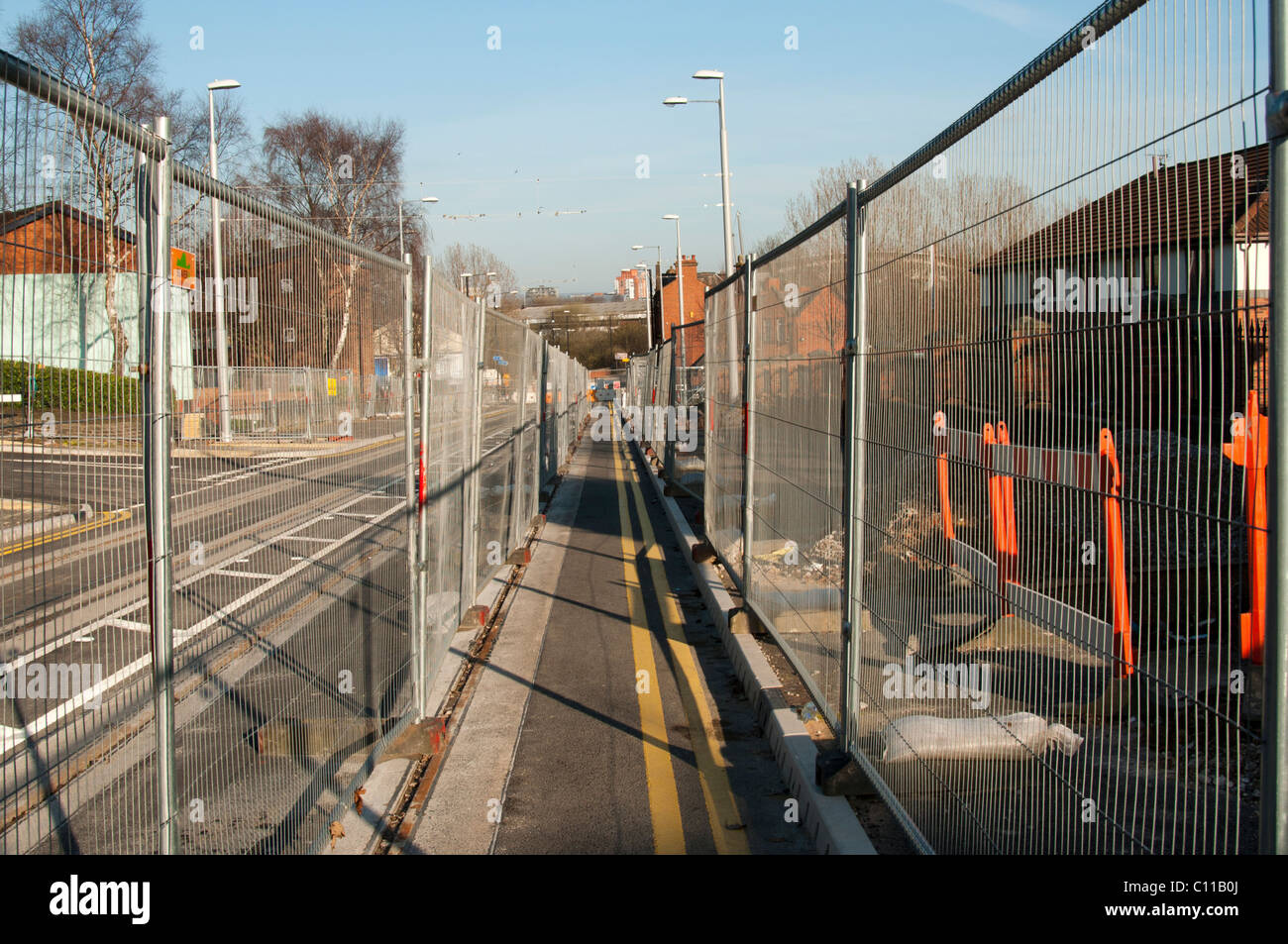 Pedestrian route between security fences, Metrolink tram route ...