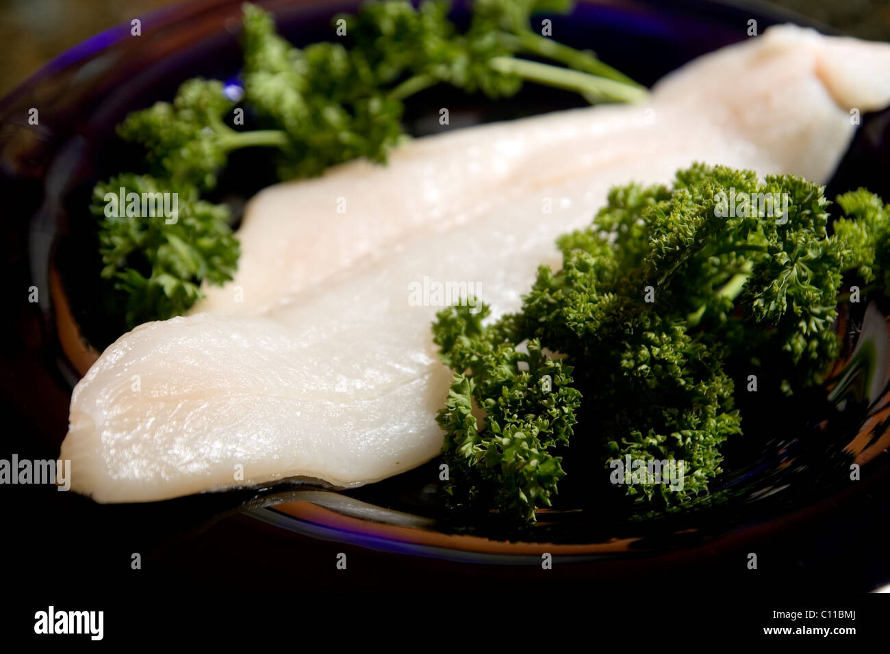 fillet of Haddock on blue plate Stock Photo - Alamy