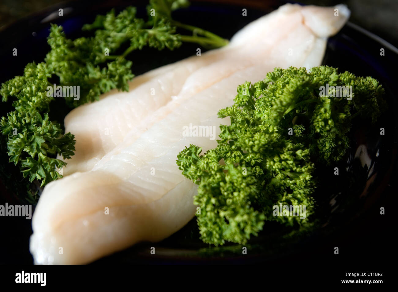 fillet of Haddock on blue plate Stock Photo - Alamy