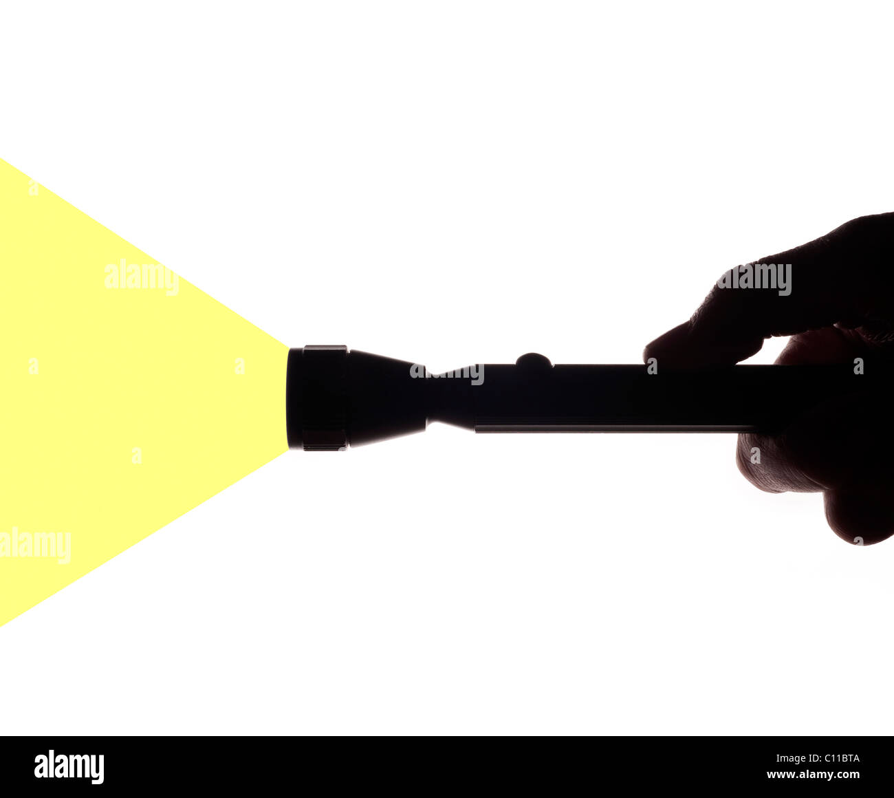Hand holding a torch shining a yellow wide beam of light on a white ...