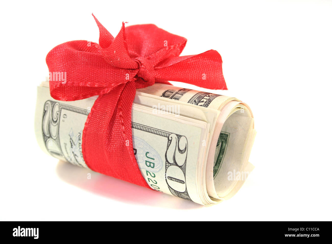 many dollar bills with a red bow on white background Stock Photo - Alamy