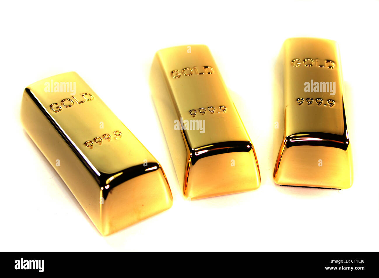 three large gold bars on a white background Stock Photo - Alamy
