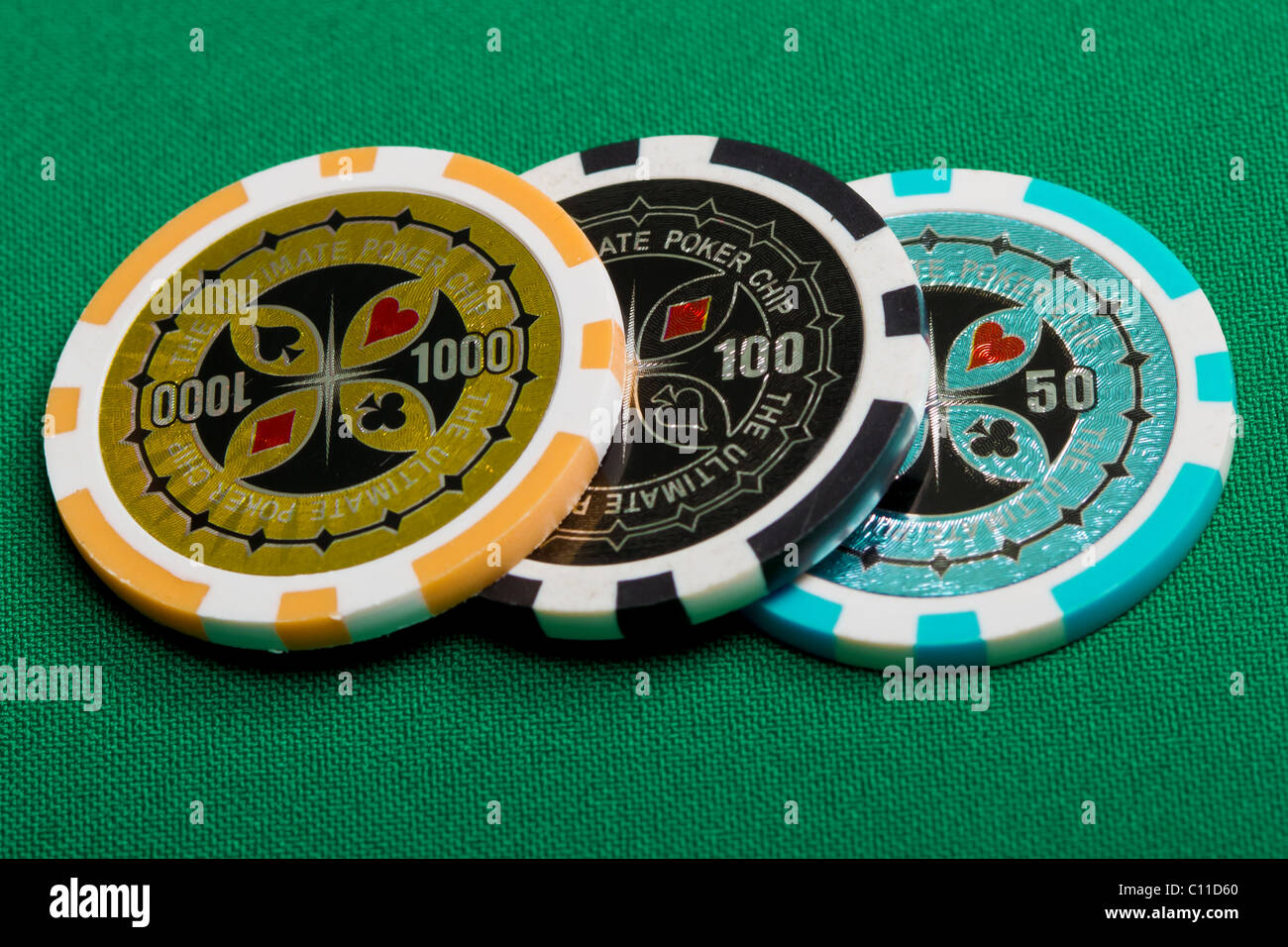 three poker chips on a green background fabric Stock Photo - Alamy