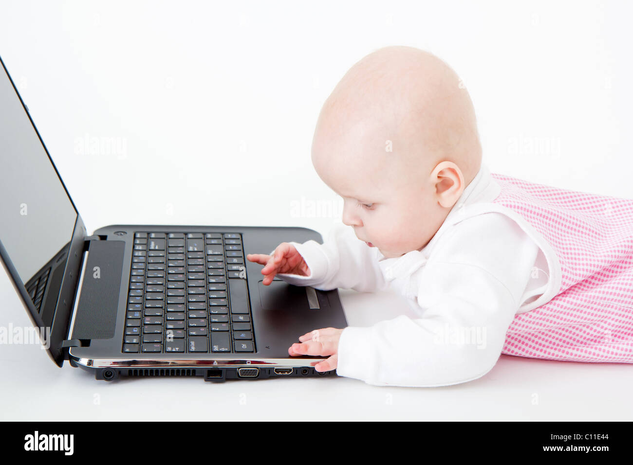 dressed the baby played with a laptop on a white background Stock Photo ...
