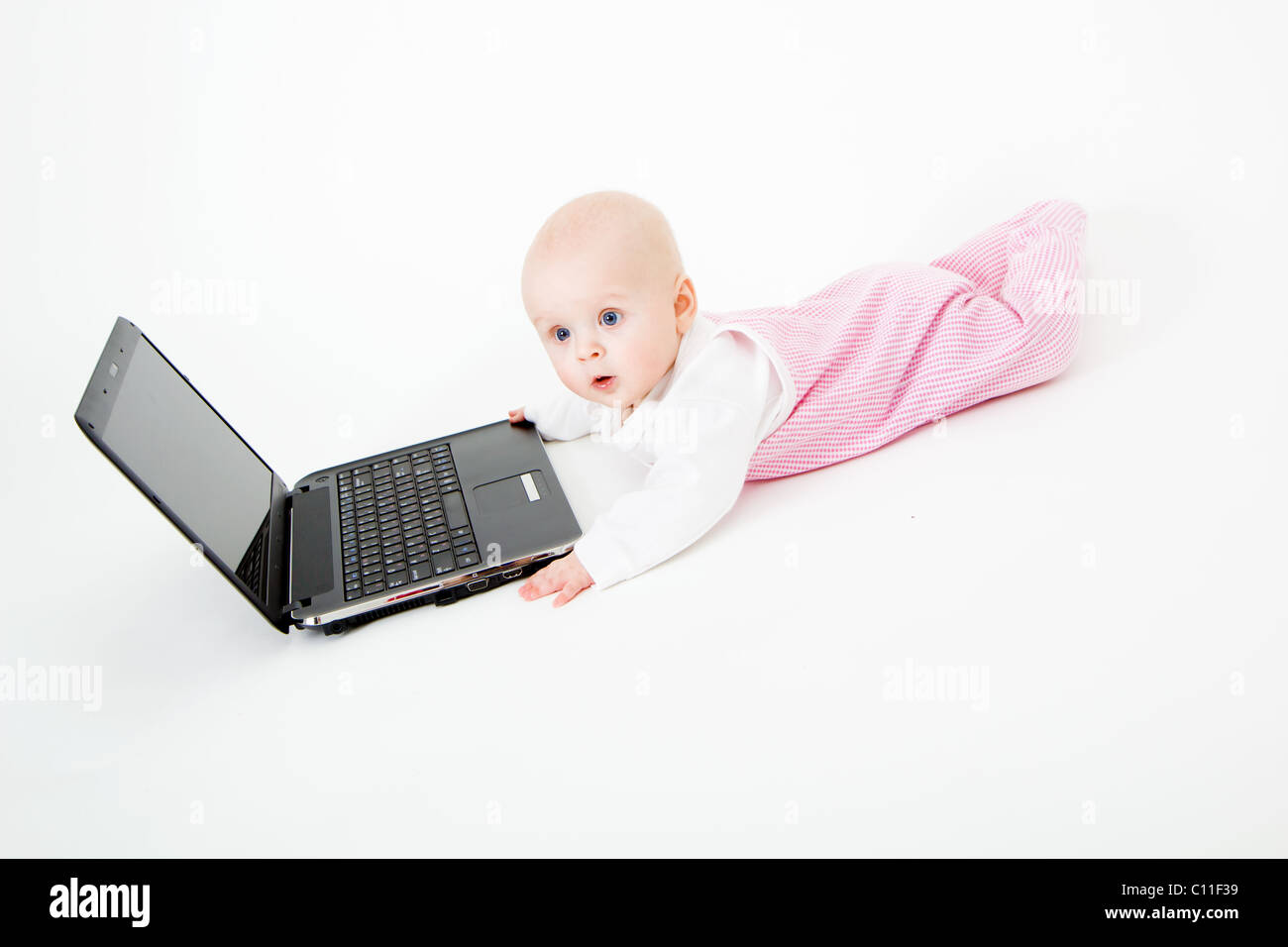 Baby playing with laptop on white background Stock Photo - Alamy