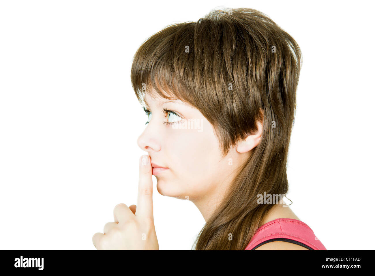 she presses the index finger to lips on an isolated white background ...