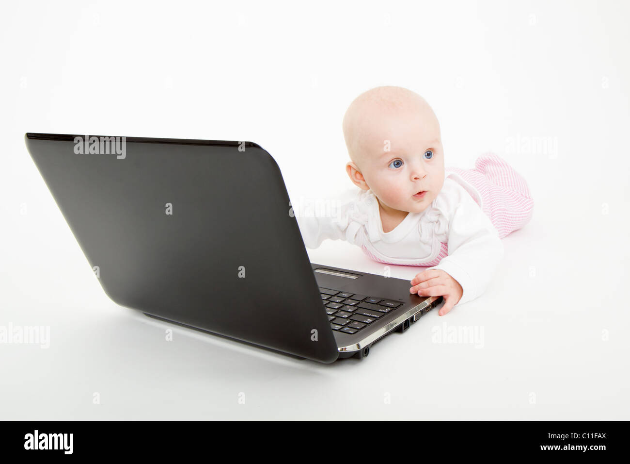 baby with laptop lying on a light background Stock Photo - Alamy