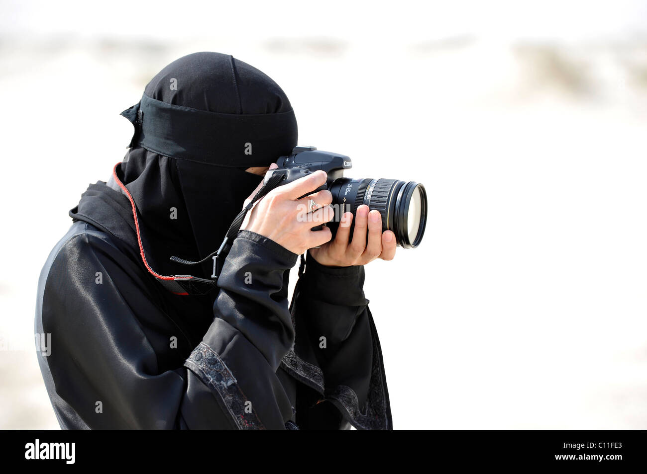 Photographer, Arab woman in traditional clothing with abayah and veil ...