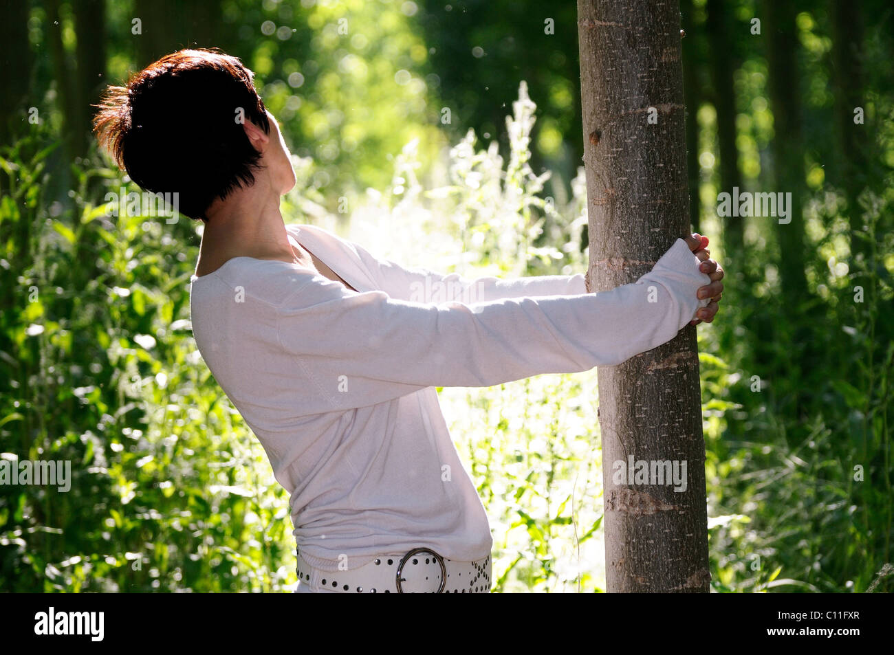 Woman hugging a tree Stock Photo - Alamy