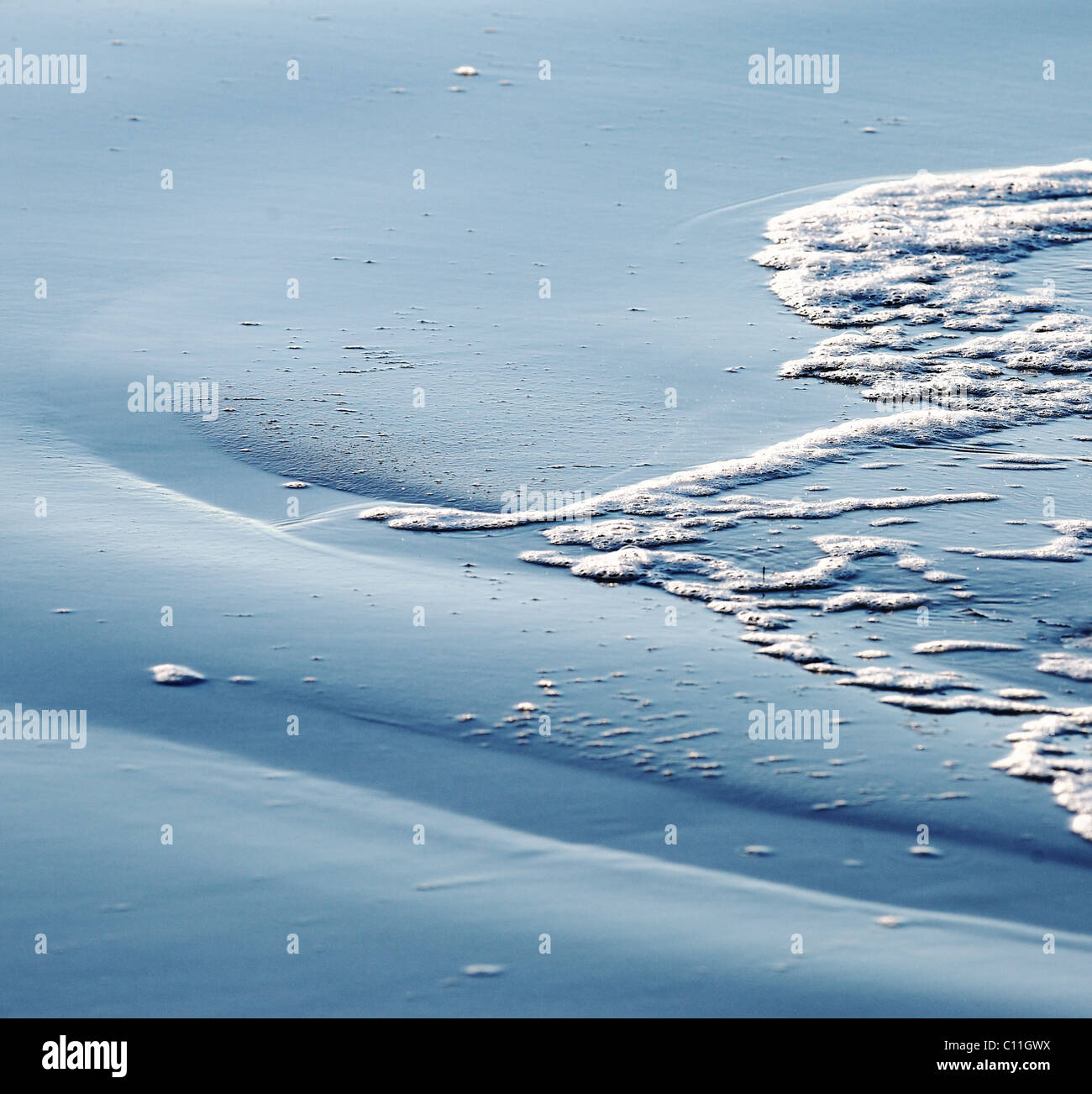 Returning wave on the beach Stock Photo - Alamy