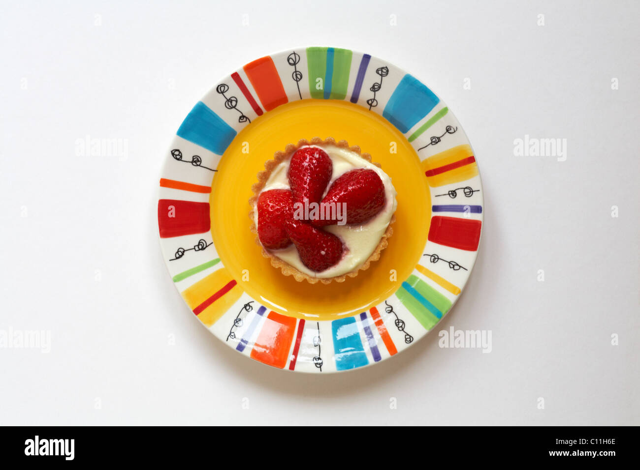 strawberry tart on yellow colourful plate on white background Stock ...