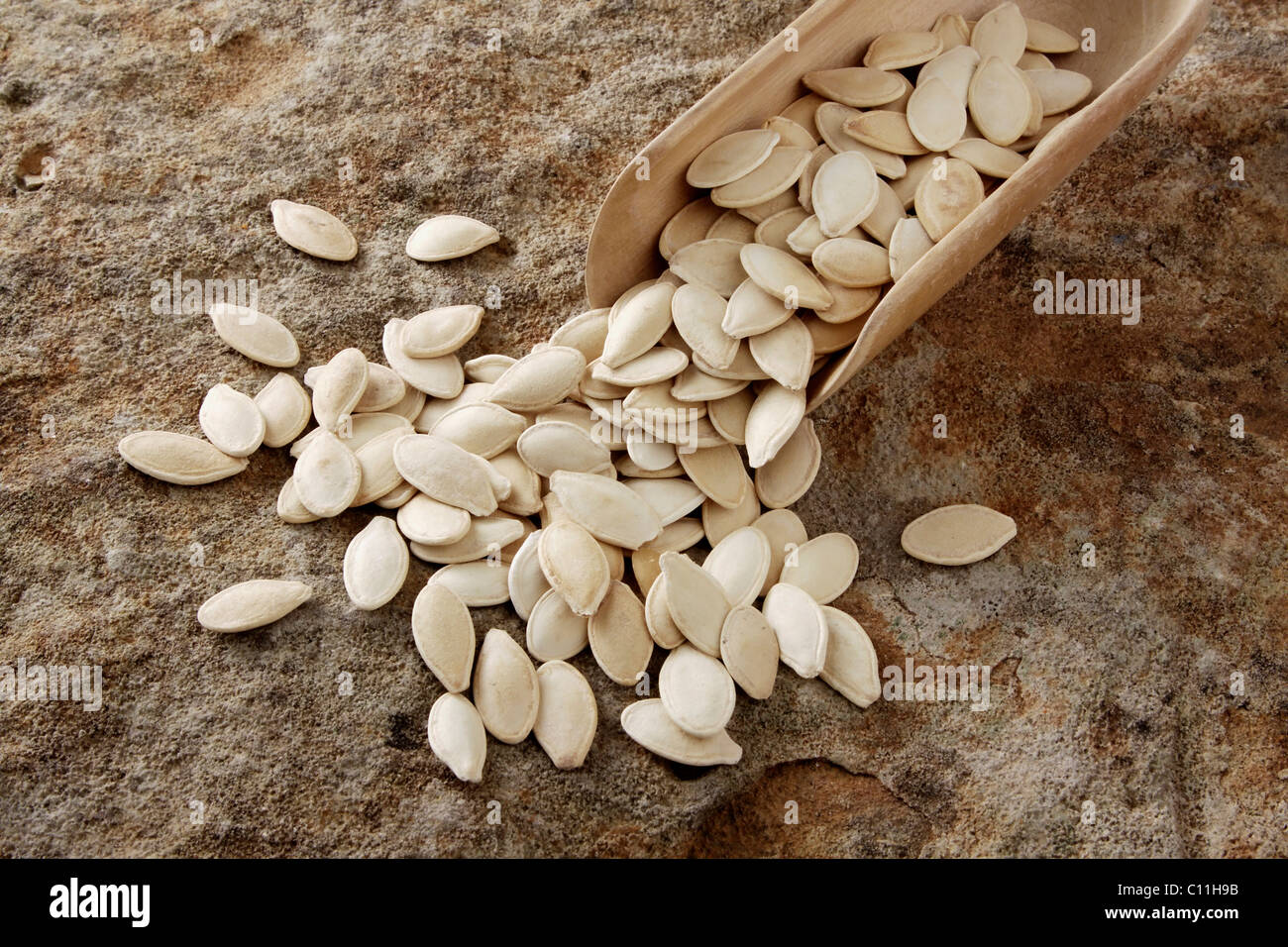 Pumpkin seeds (Cucurbita) with a wooden shovel, on stone surface Stock ...