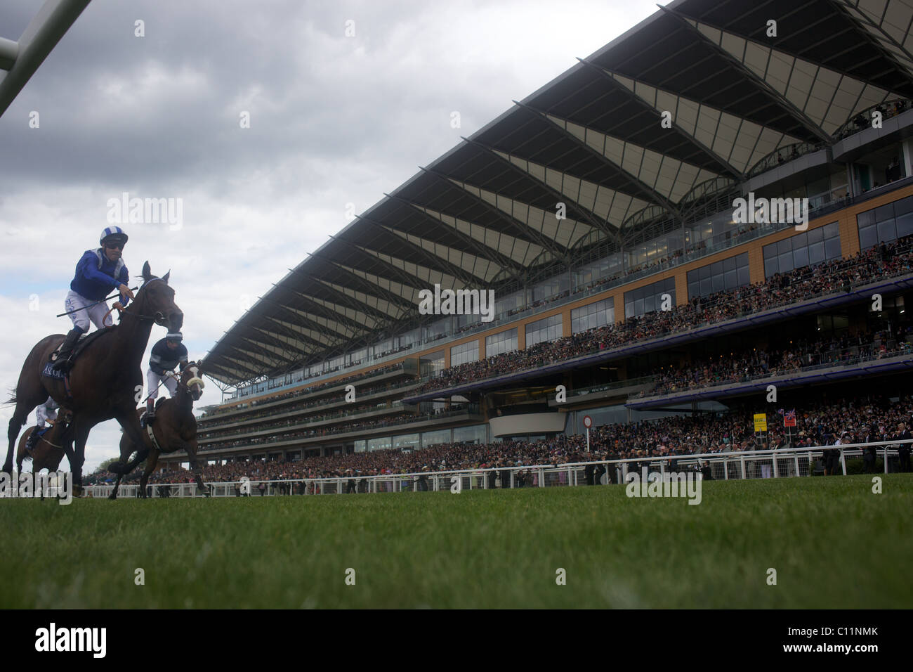 Horses race past the main grandstand towards the finish post at the ...