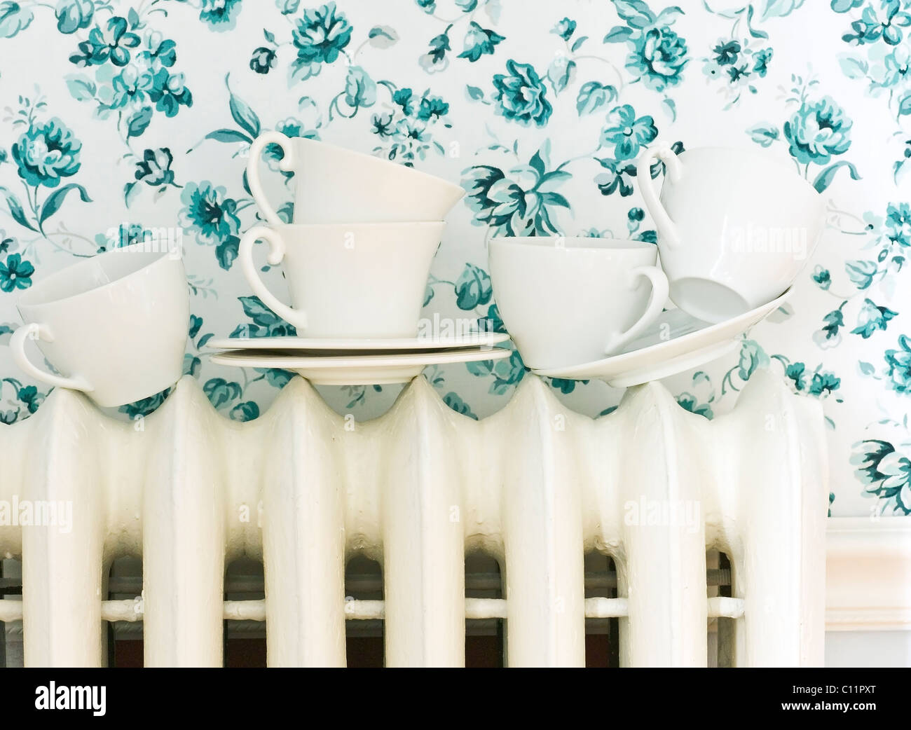 Tea Cups on Radiator with Blue Flowered Background Stock Photo - Alamy
