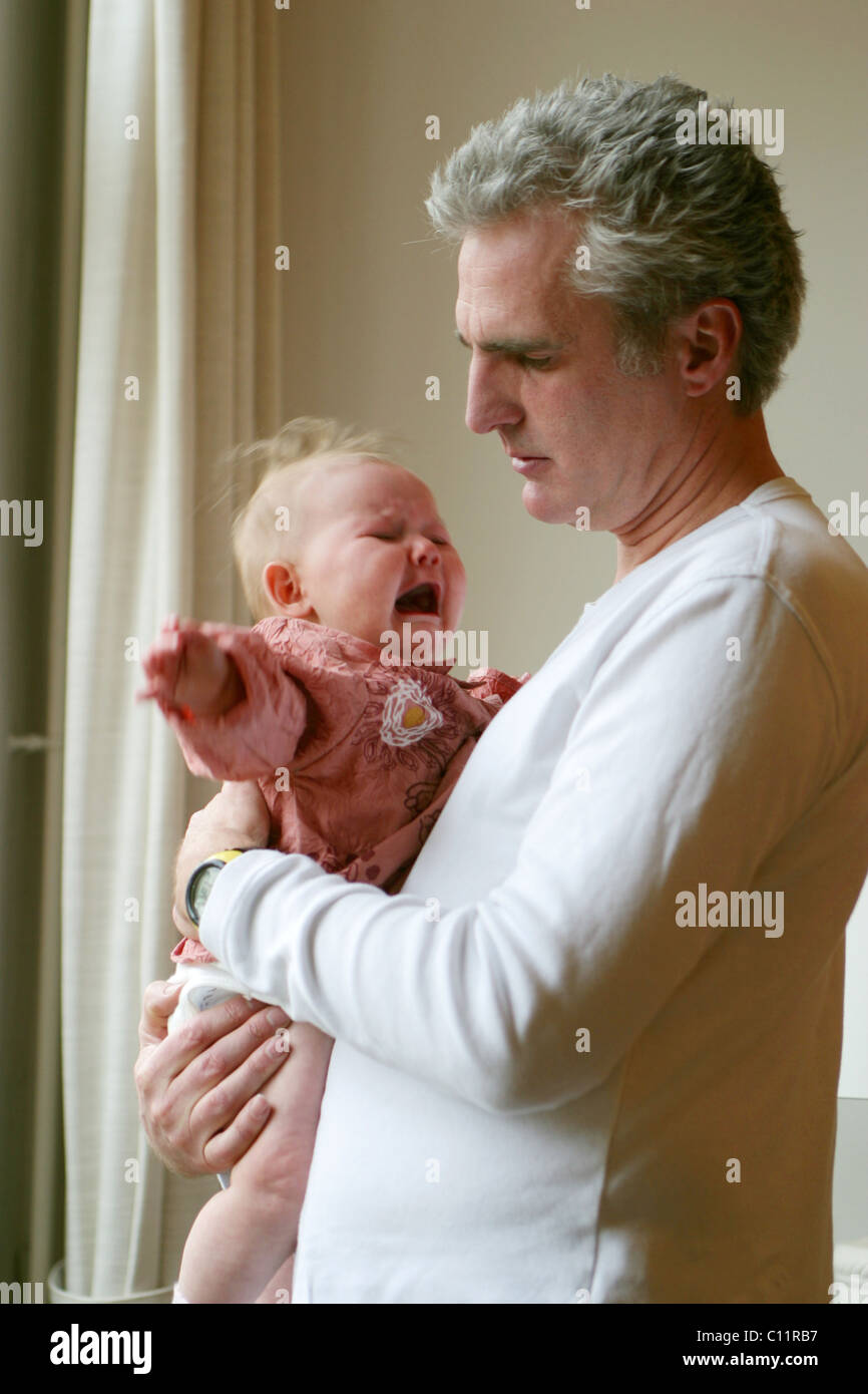 Man holds crying baby hi-res stock photography and images - Alamy