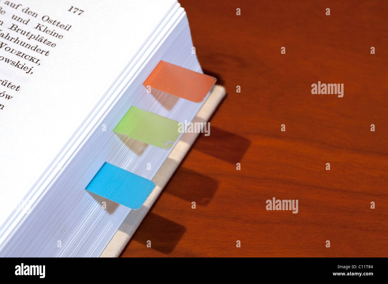 Thick book with bookmarks in different colours Stock Photo - Alamy