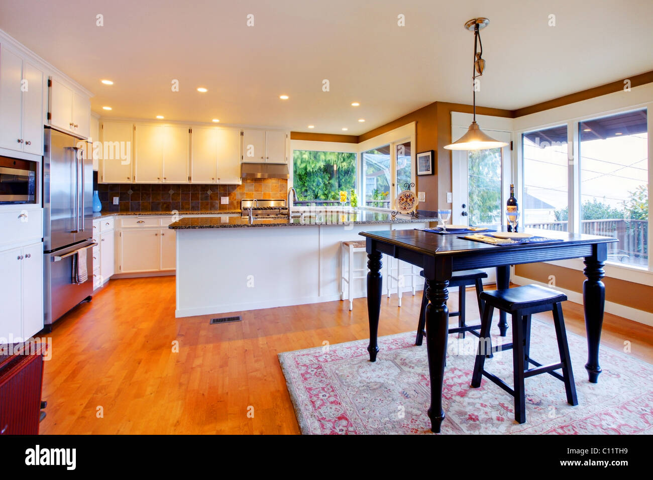 Luxury white kitchen, oak floors and beautiful granite Stock Photo - Alamy
