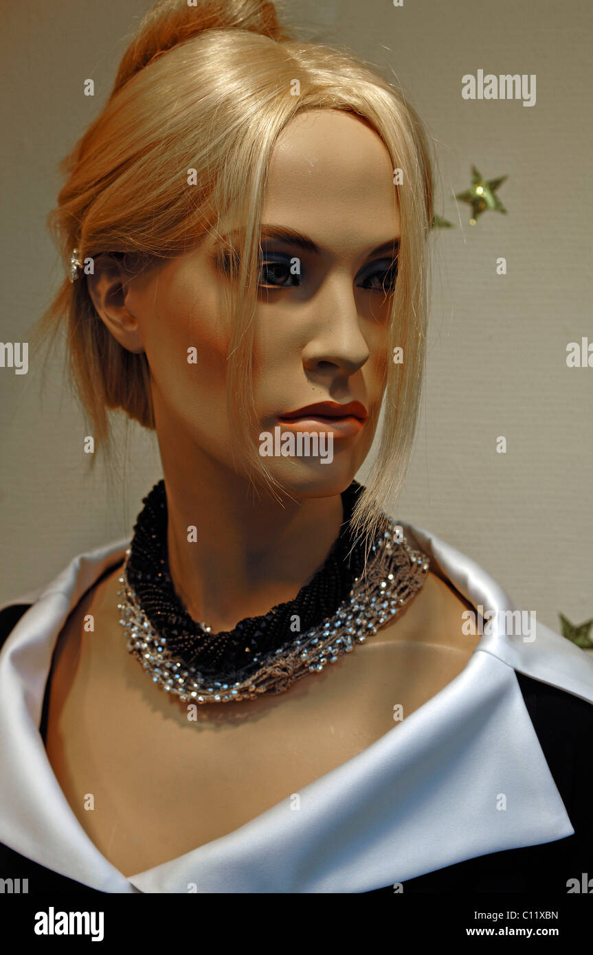 Female window dummy with blonde hair and necklaces, in a fashion shop ...