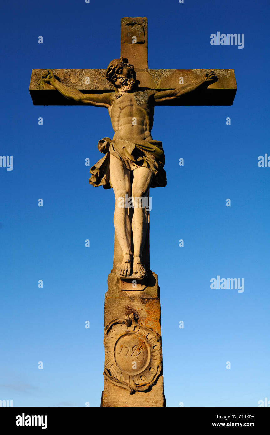 Stone crucifix from 1795 against a blue sky, Illhaeusern, Alsace ...