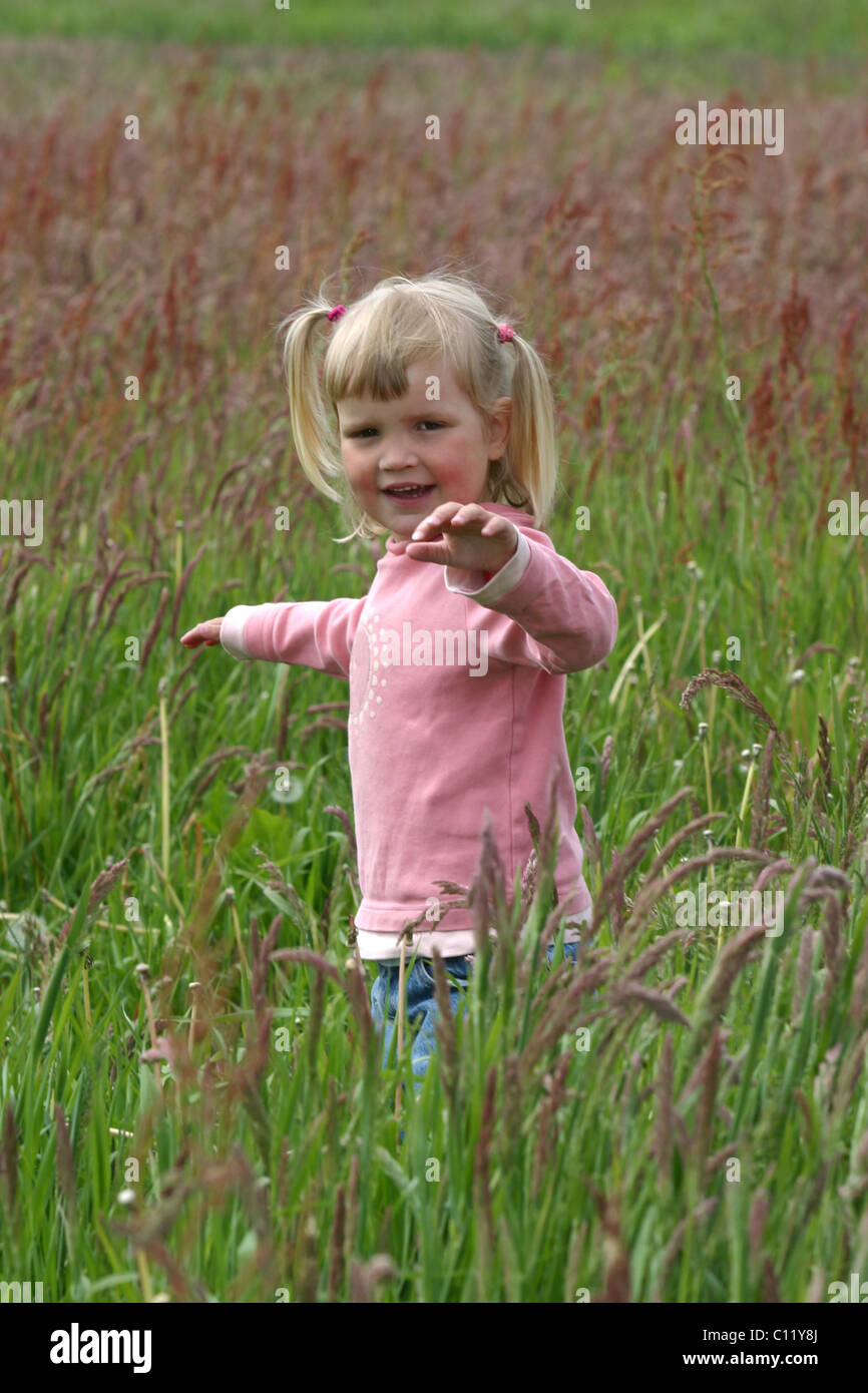 Child playing in meadow land Stock Photo - Alamy