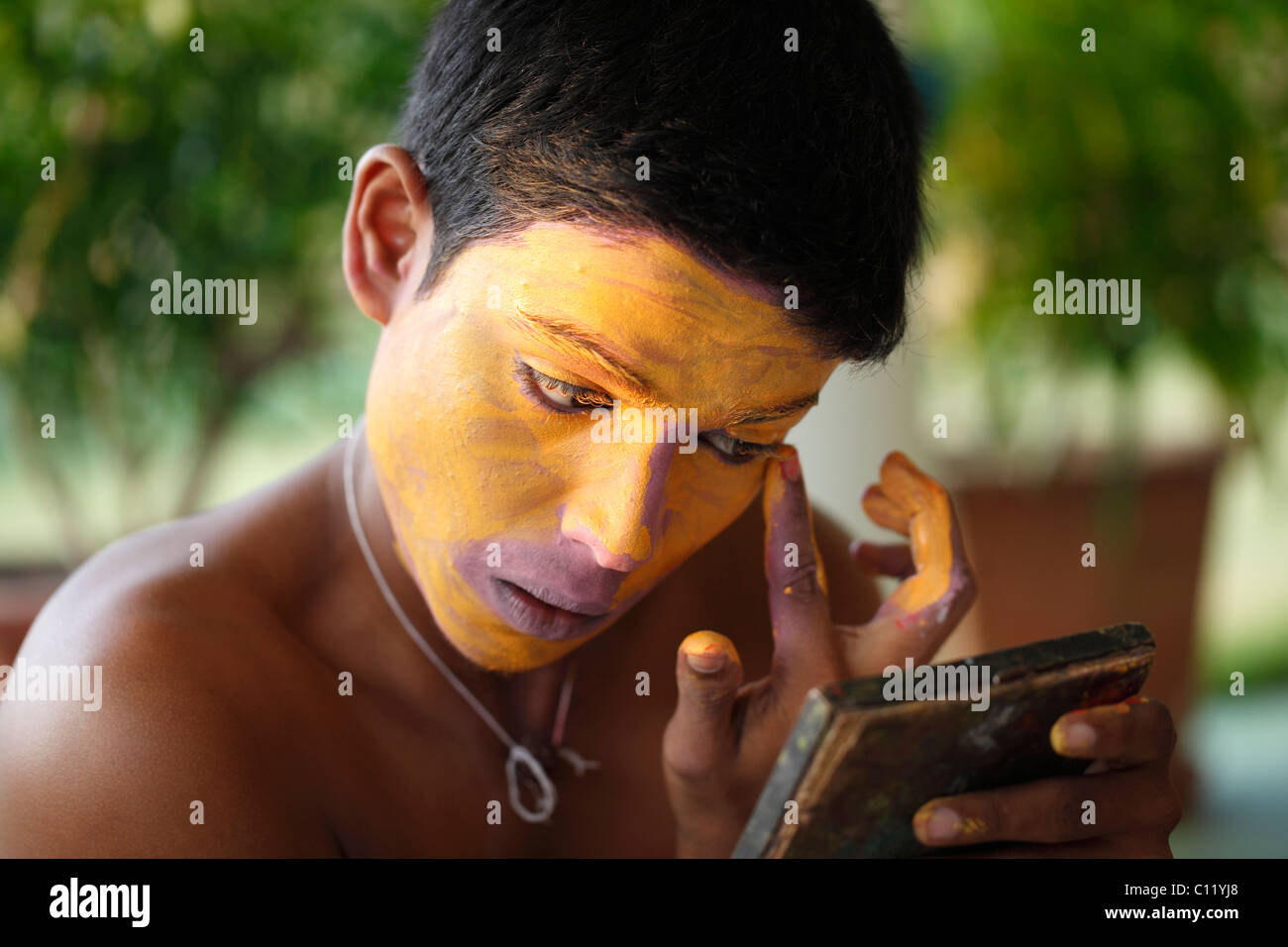 Kathakali dancer doing his make up, Minukku character, Kerala, southern ...