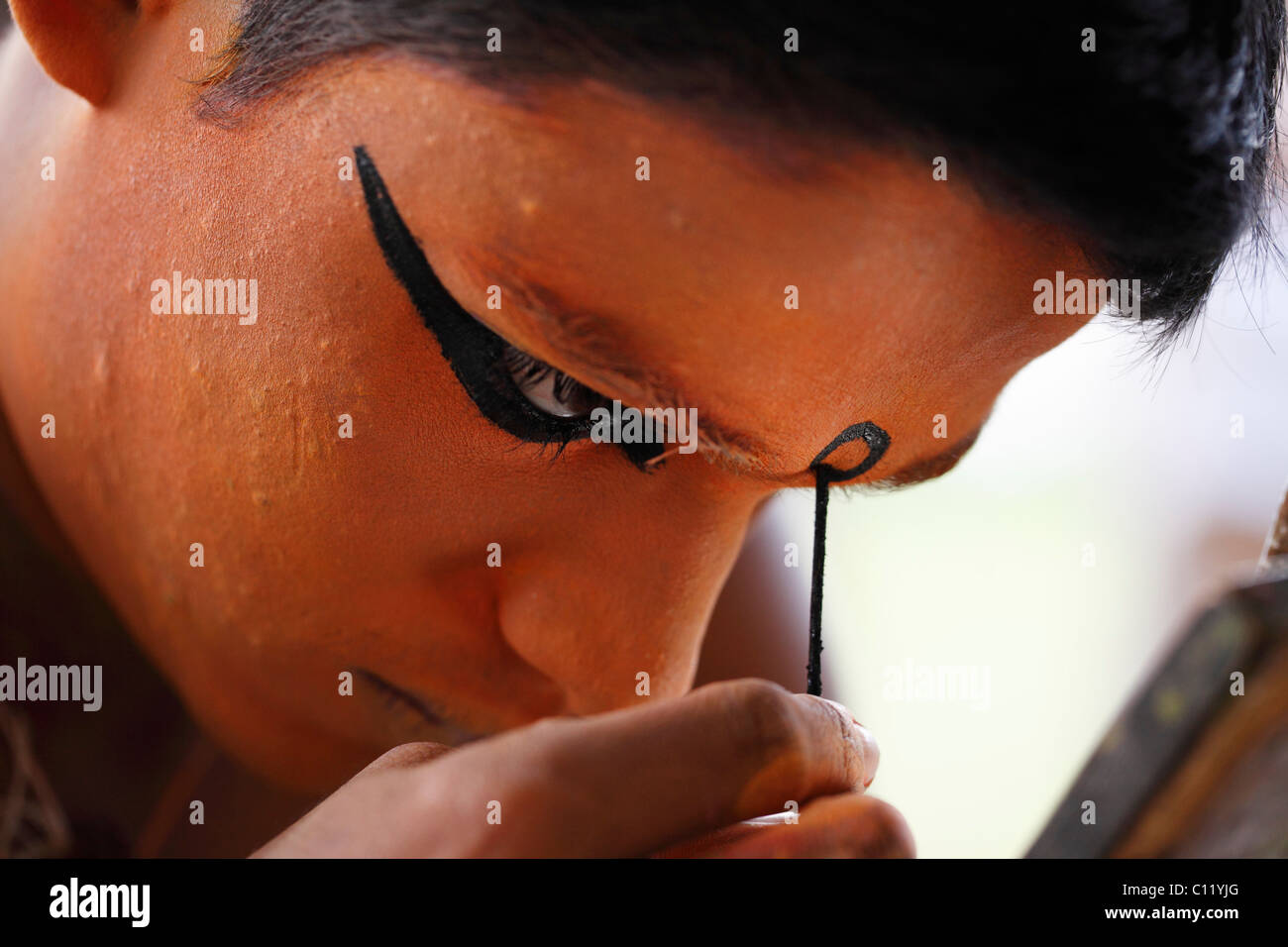 Kathakali dancer doing his make up, Minukku character, Kerala, southern ...