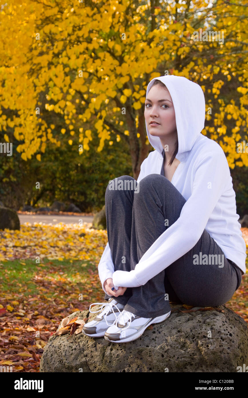 Young woman sitting in park Stock Photo - Alamy