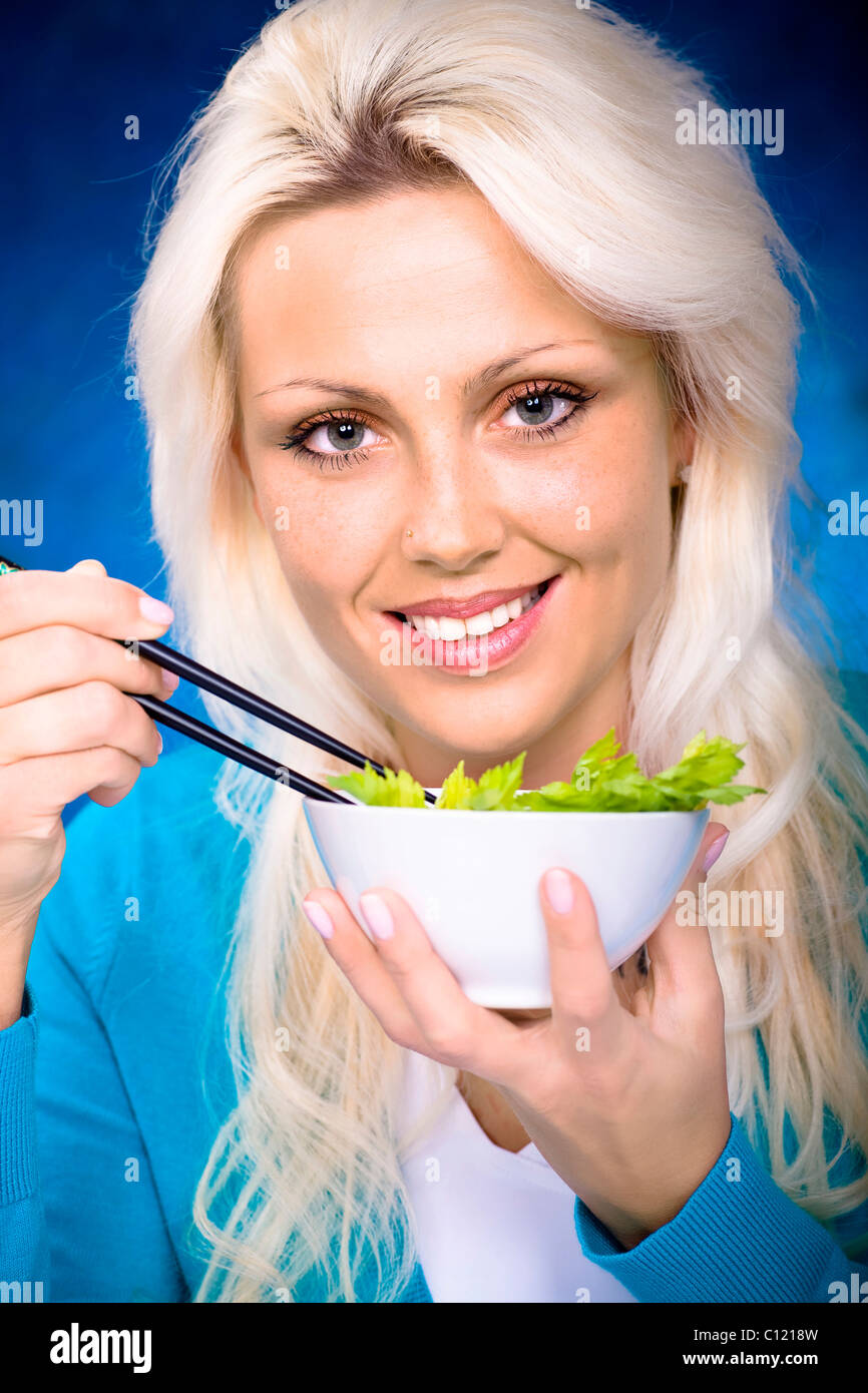 Young woman eating from bowl with chopsticks Stock Photo - Alamy