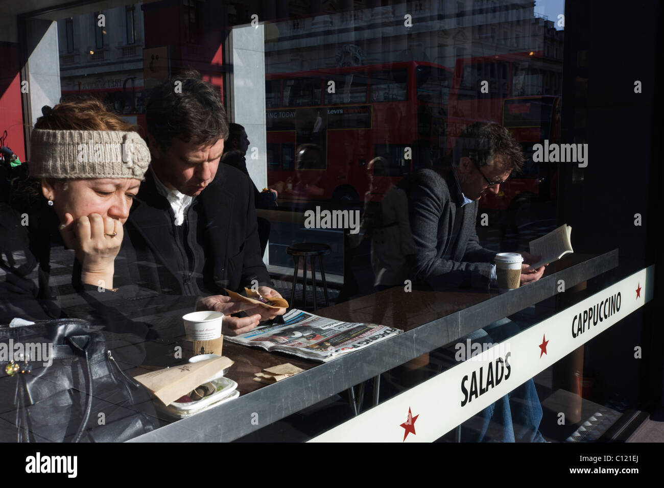 Lunchtime diners in a sunlight window of a London Pret a Manger ...