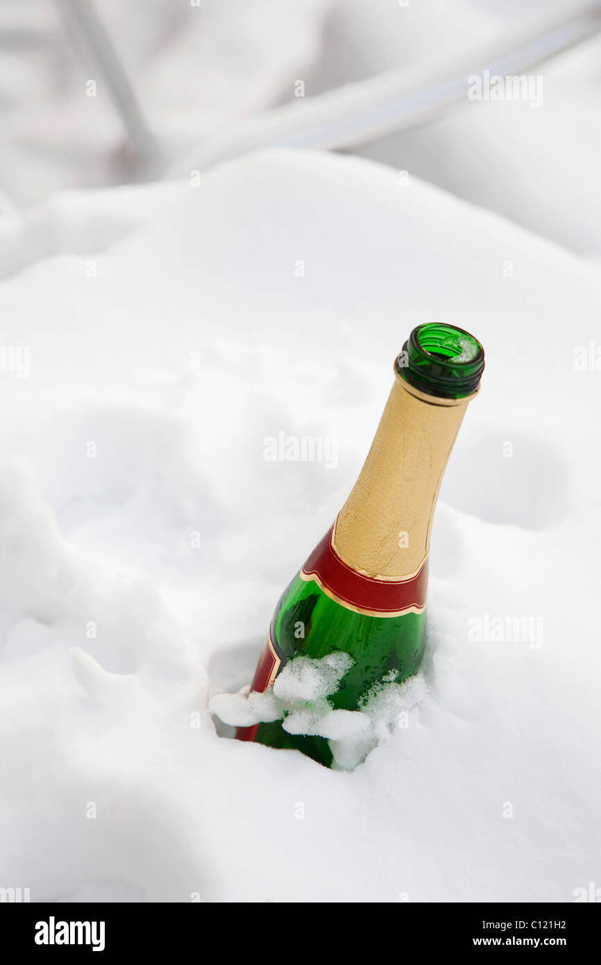 An empty champagne bottle in the snow Stock Photo - Alamy