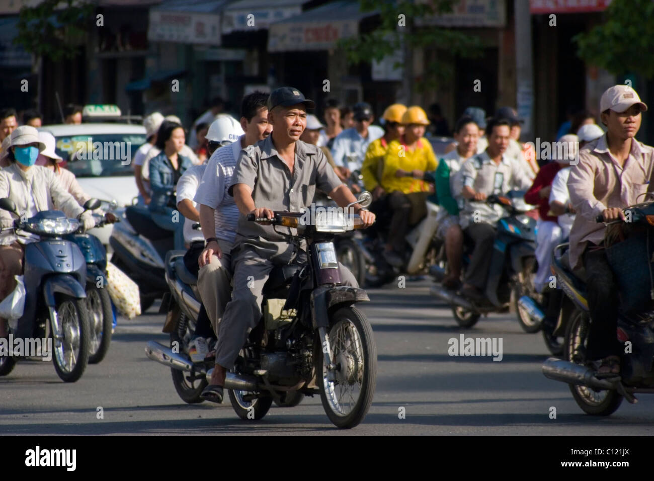 People are driving motorcycles in heavy traffic on a street in Saigon ...