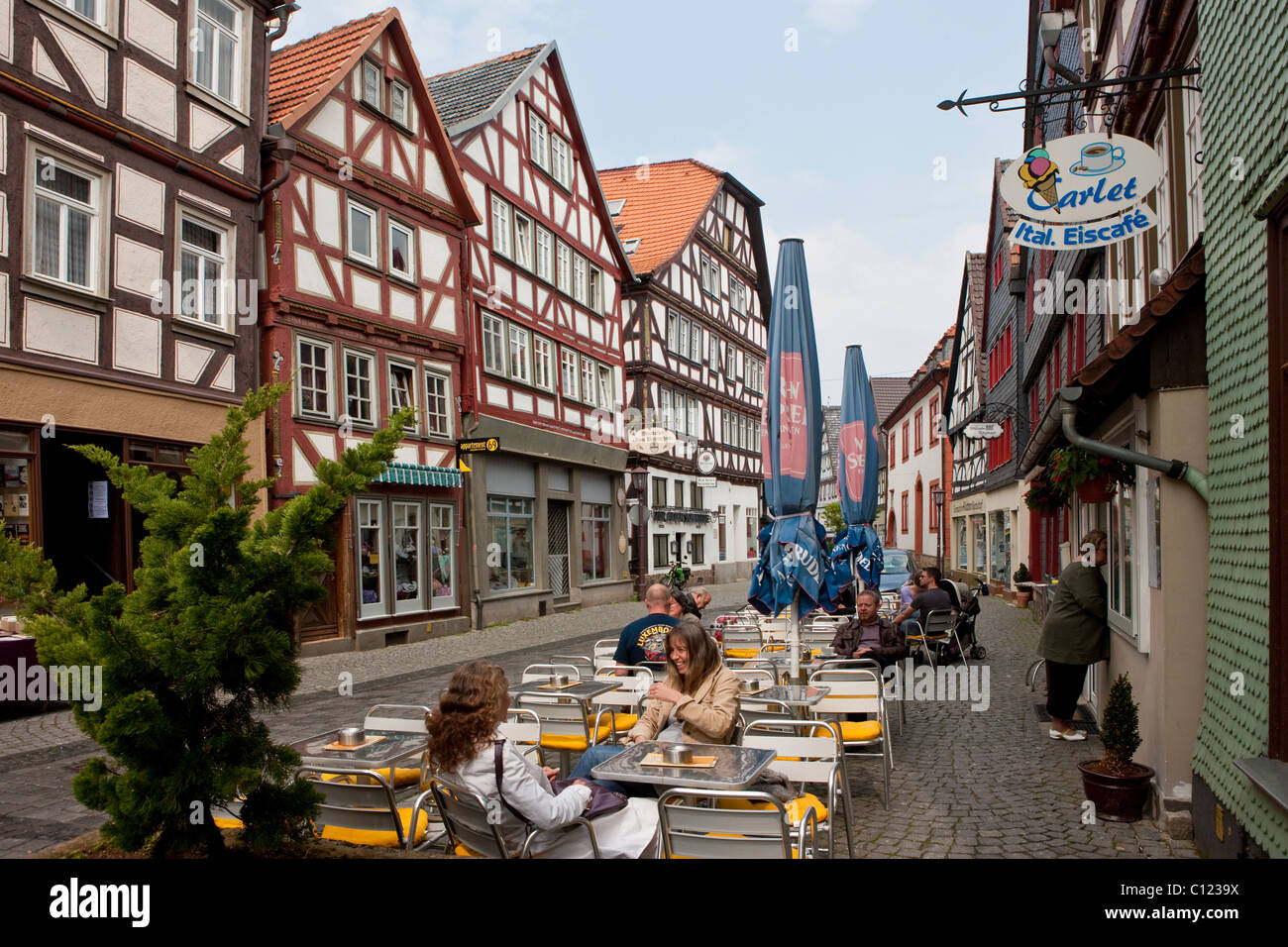 Tourists sitting in a cafe in the historic town centre, Alsfeld, Hesse ...