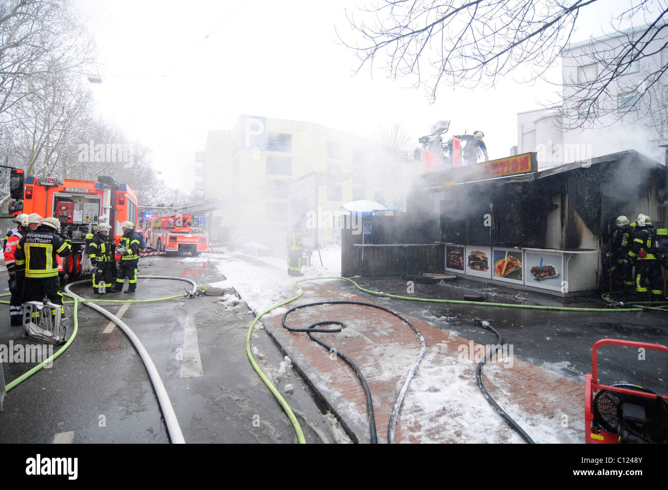 Fire brigade extinguishing a fire in a burnt-out snack stand, Stuttgart ...