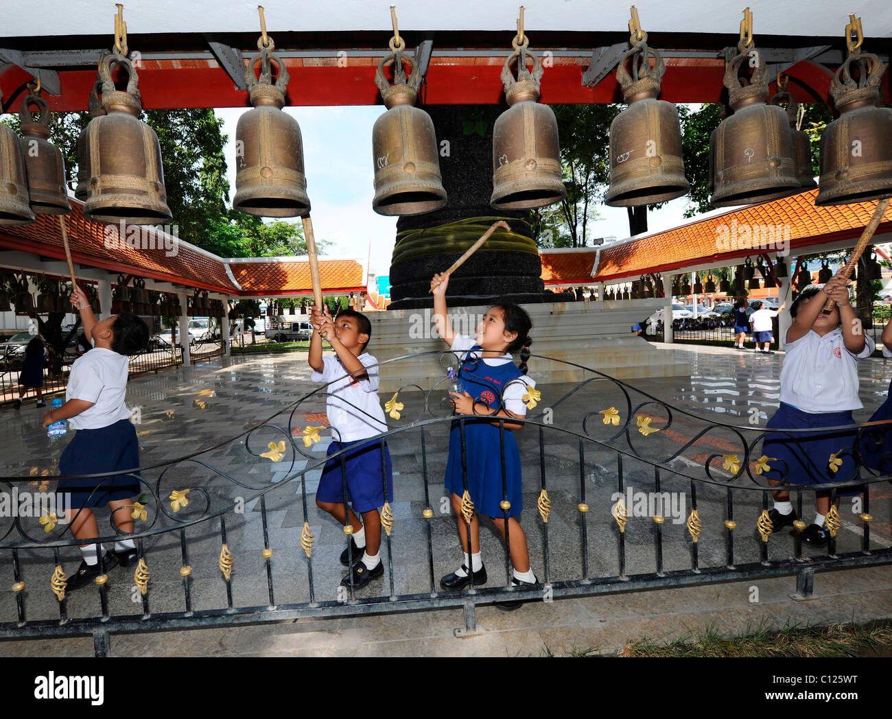 Children striking a bell, Thailand, Asia Stock Photo - Alamy