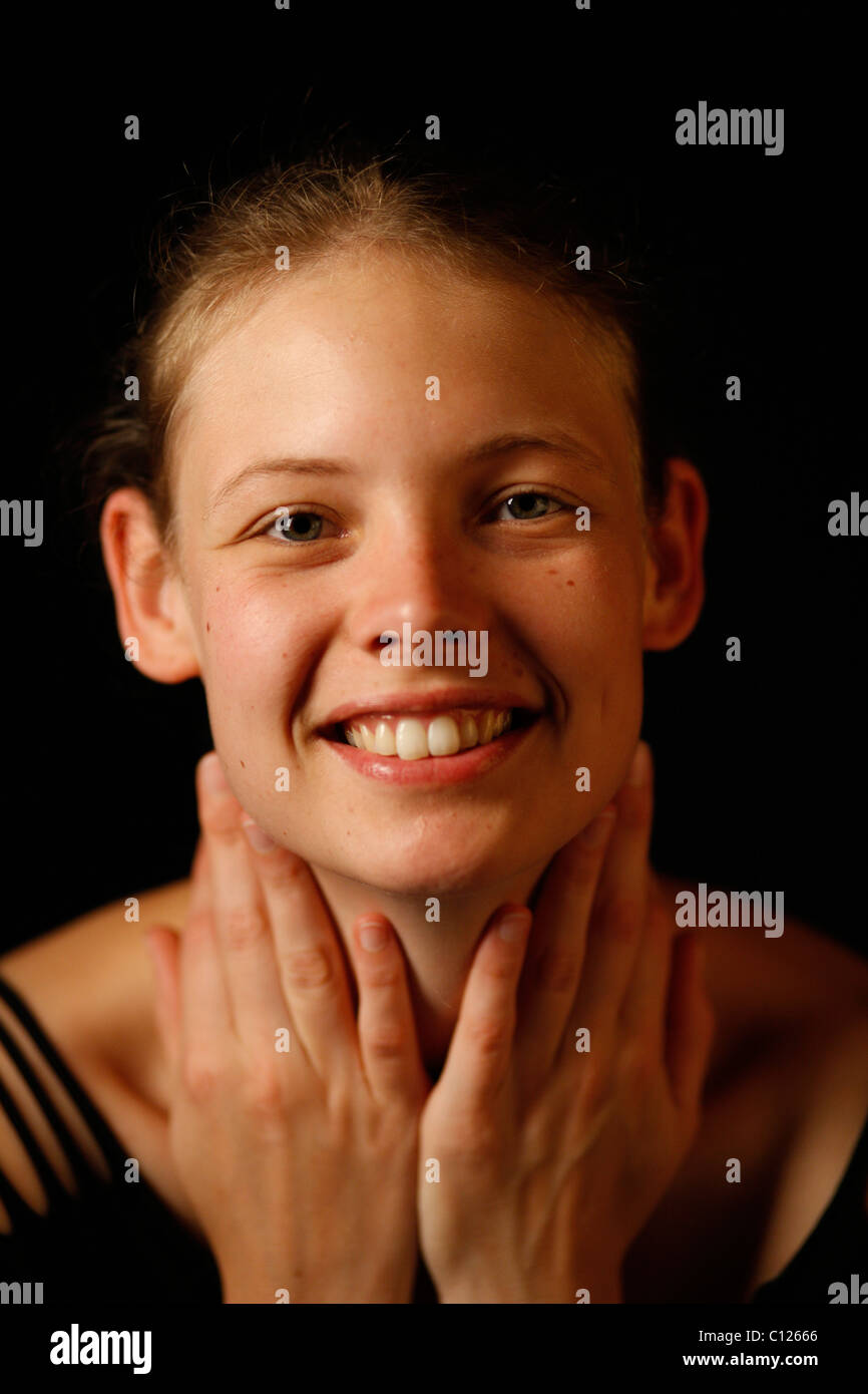 Young woman putting her hands to her neck Stock Photo - Alamy