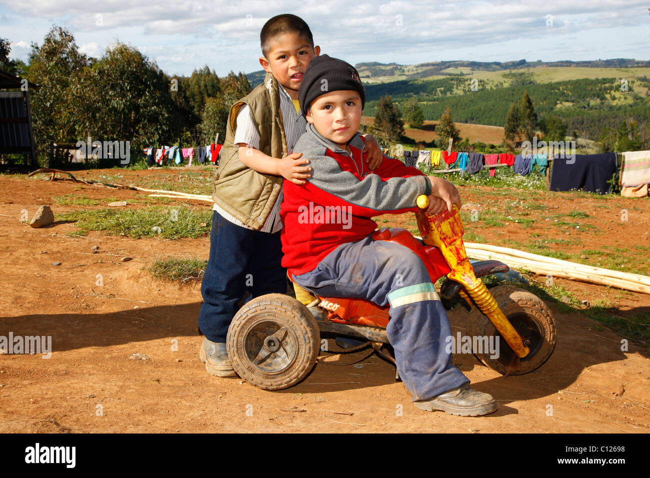 Two boys playing with a tricycle, Mapuche Indians, near Concepción ...