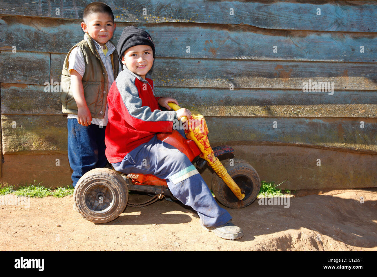 Two boys playing with a tricycle, Mapuche Indians, near Concepción ...
