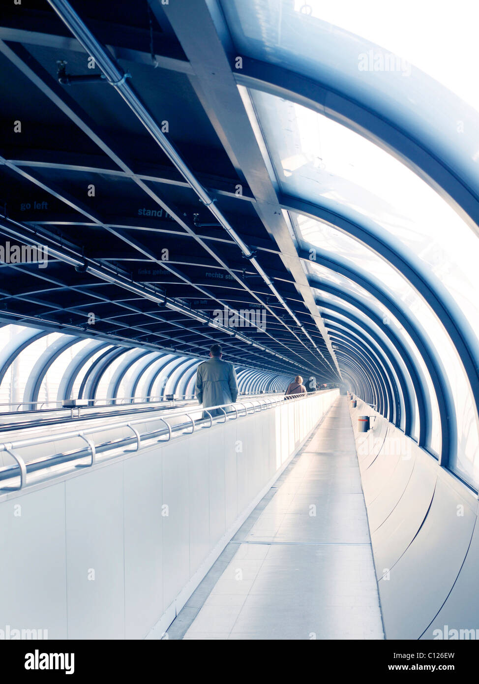 Visitors to the fair on a moving walkway in a connection corridor ...