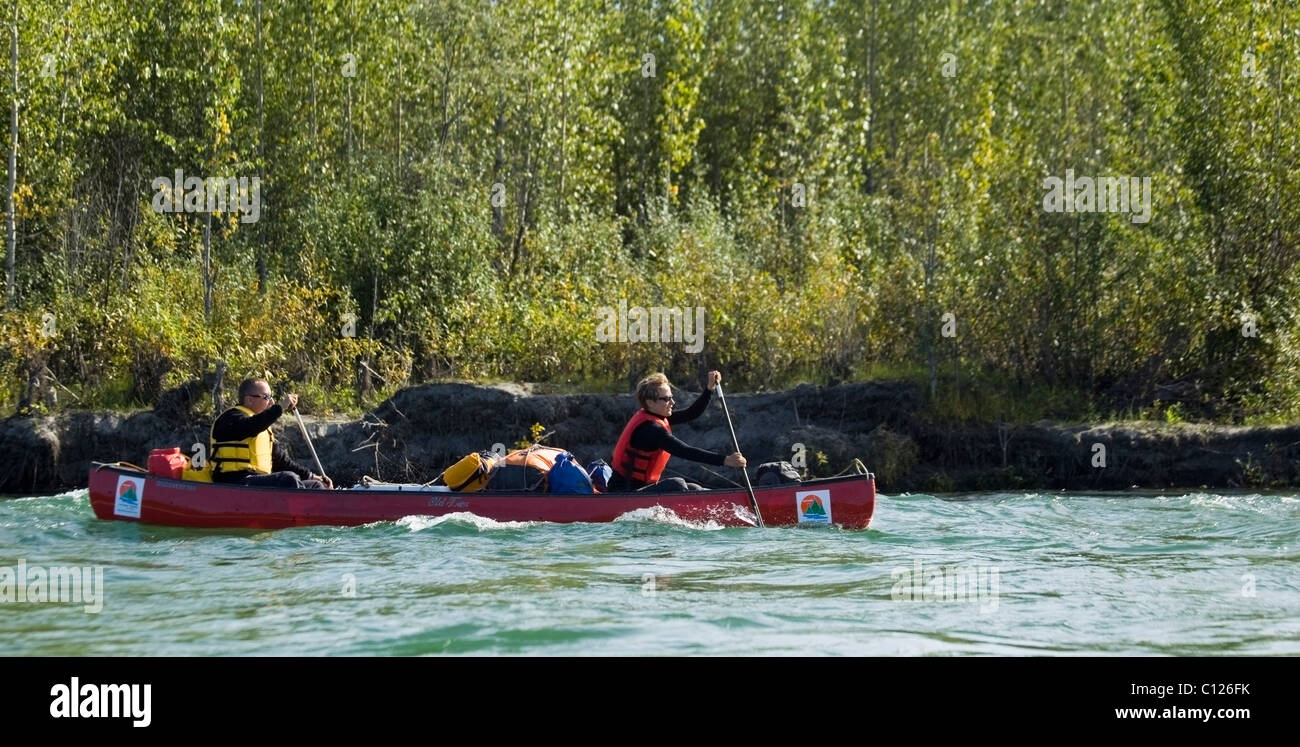 Couple, man and woman paddling a canoe, swift, fast water, canoeing ...