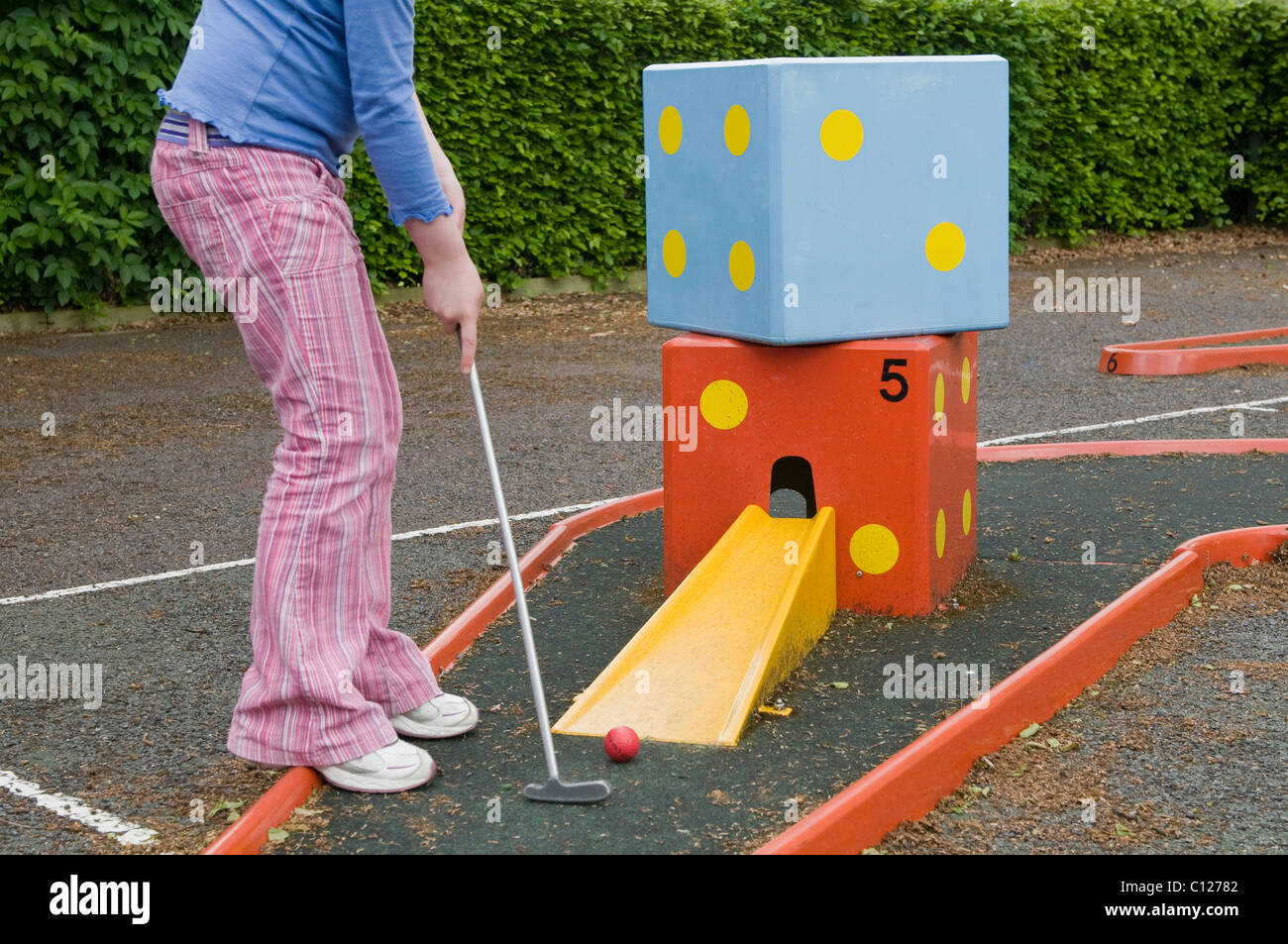 A young girl playing crazy golf Stock Photo - Alamy