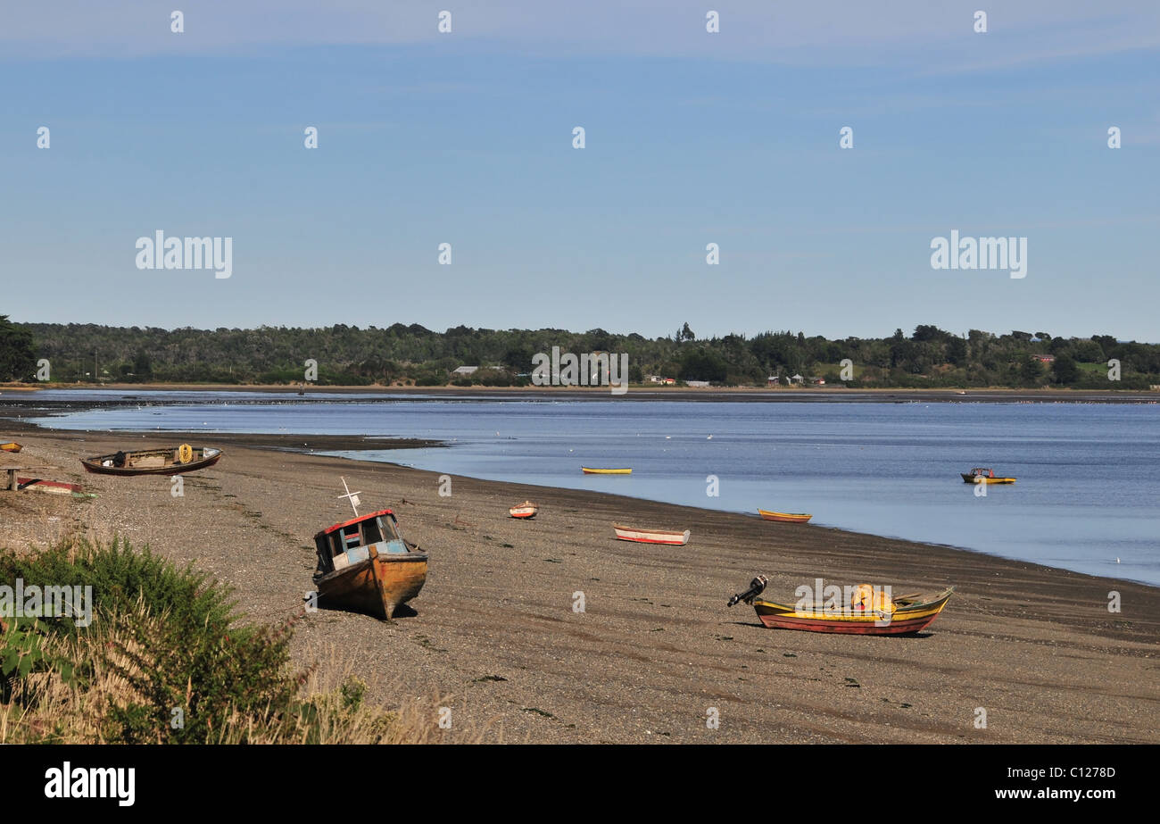 Blue sky view of small fishing boats lying on the steep beach around ...
