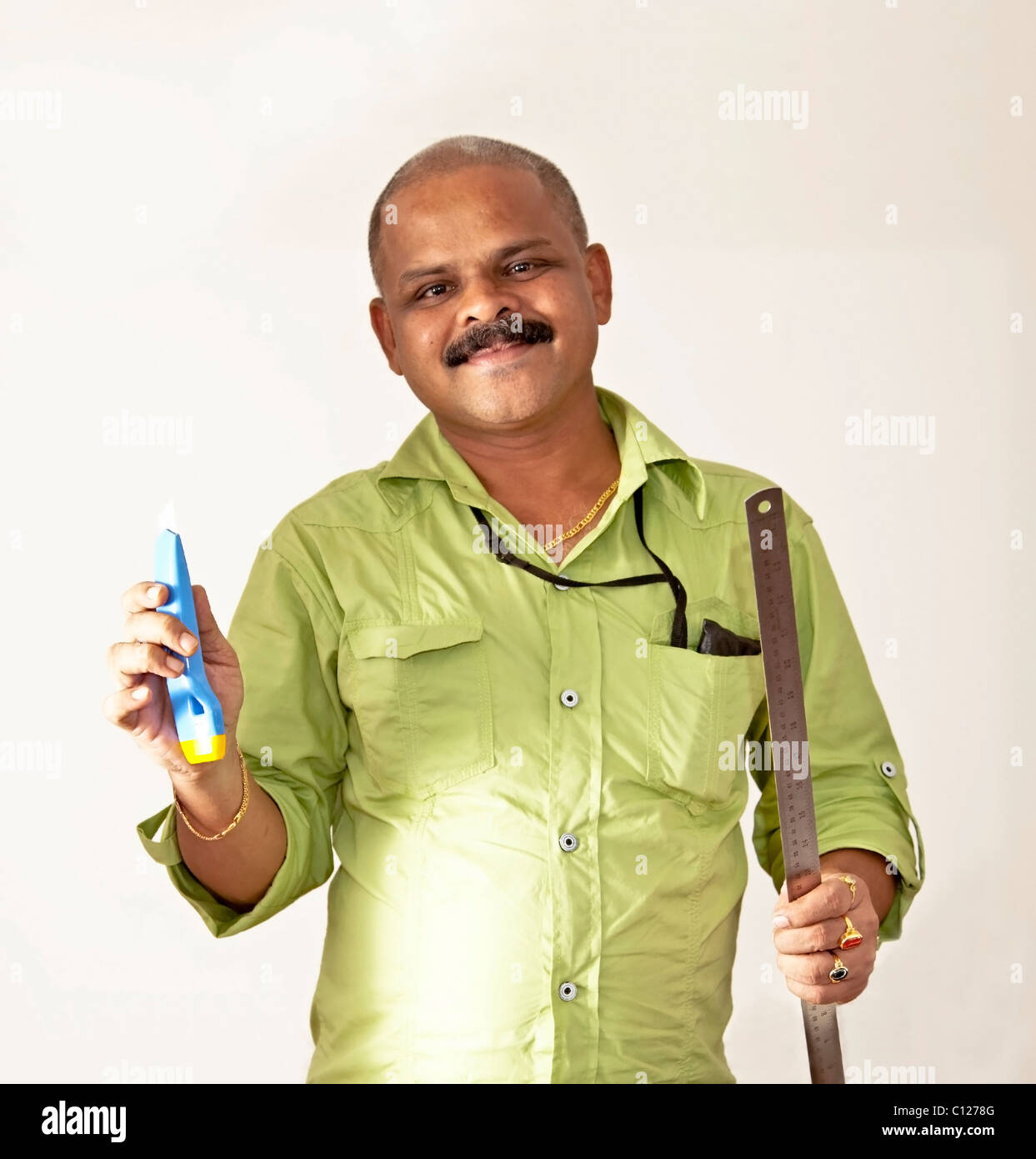 smiling indian journeyman with tools of his trade on a light background ...