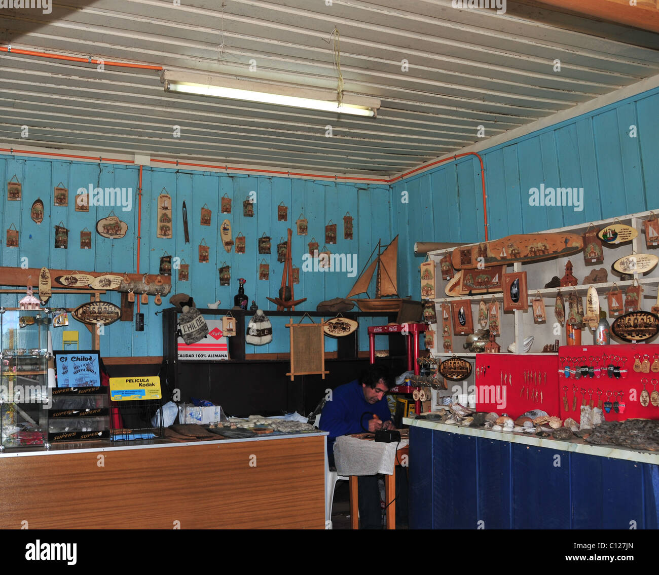 Interior view of an artesania souvenir craft-shop, with a man working ...